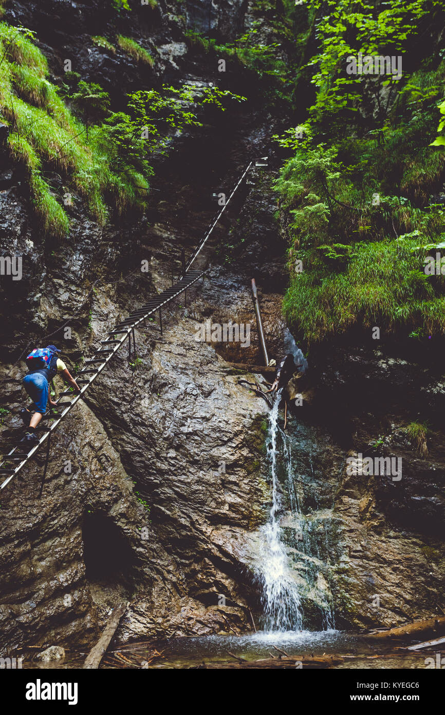 Hiker is climbing up to the rock in the Tatra Mountains in Slovakia ...