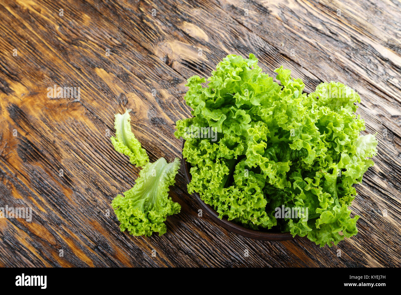 lettuce in a clay plate on a wooden table, top view Stock Photo - Alamy