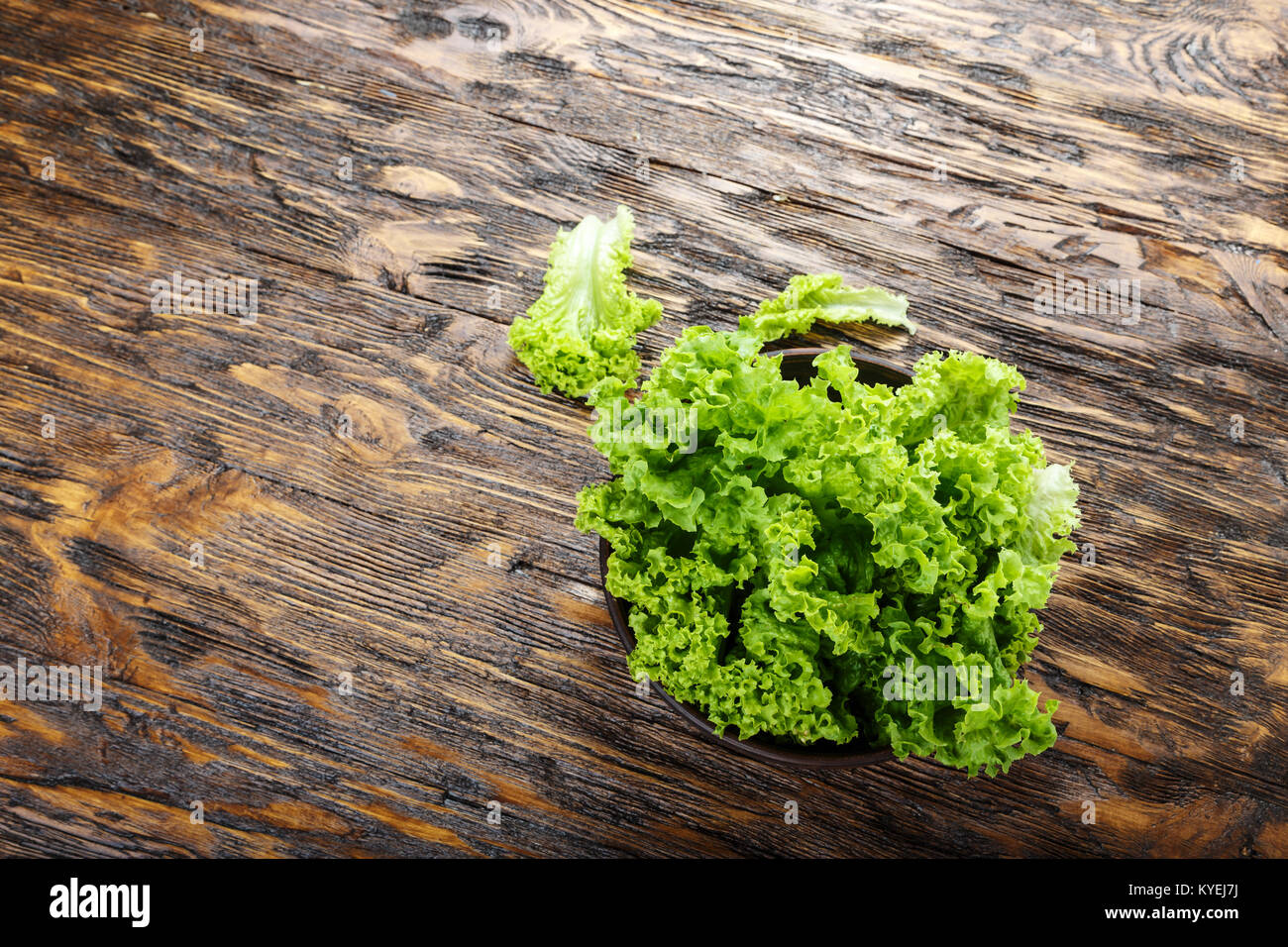 lettuce in a clay plate on a wooden table, top view Stock Photo - Alamy