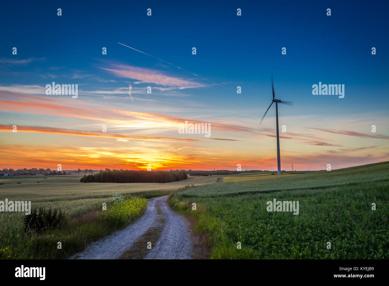 Stunning dusk over green field wind turbines in summer Stock Photo - Alamy