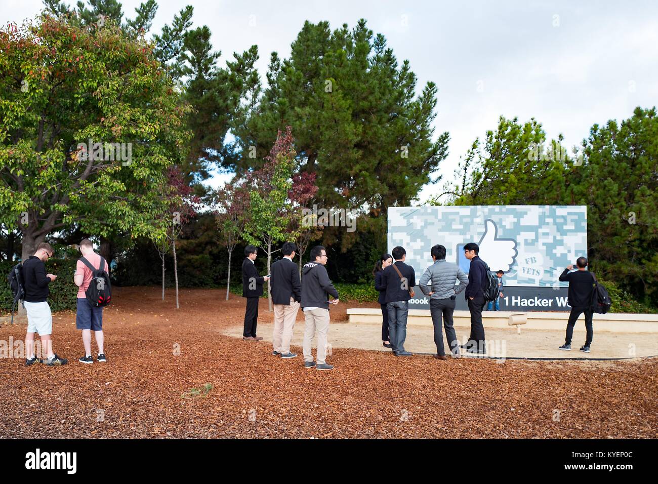 A large group of visitors stands with the main sign at the entrance of ...