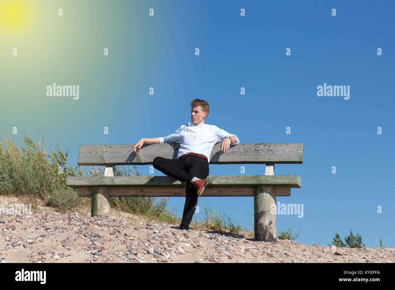 young man sitting on bench Stock Photo - Alamy