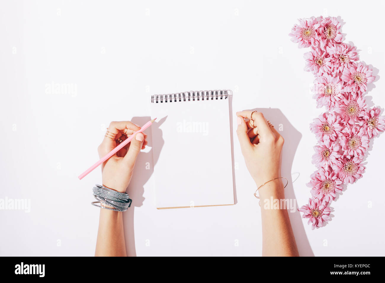 Female hands writing in notepad pink pencil top view Stock Photo - Alamy