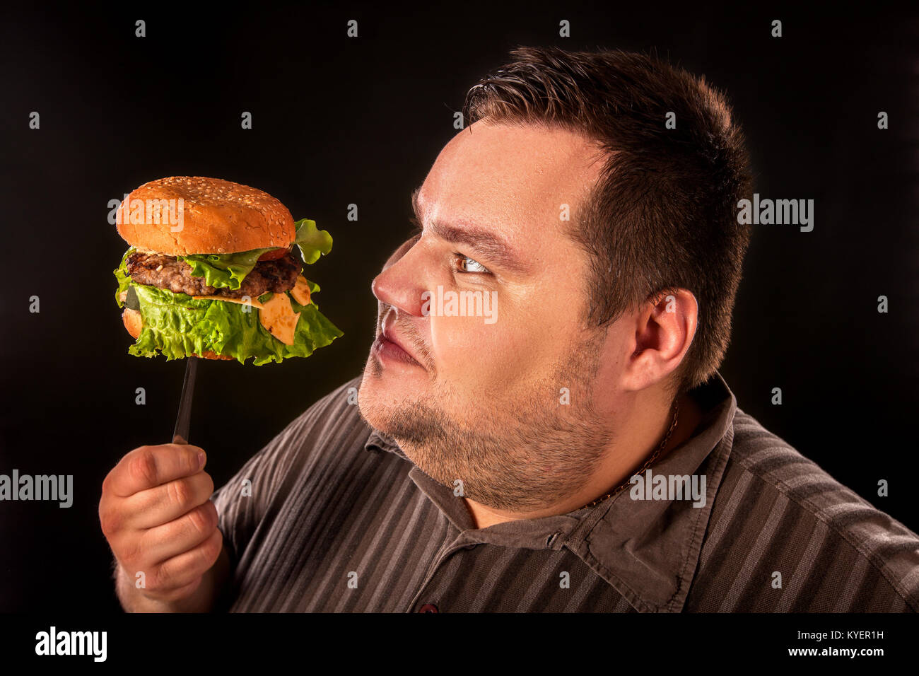 Fat man eating fast food hamberger. Breakfast for overweight person ...