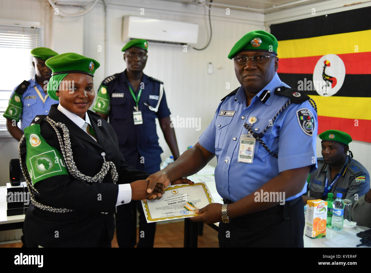 AMISOM Police Chief of Staff Rex Dundun awards a certificate to a ...