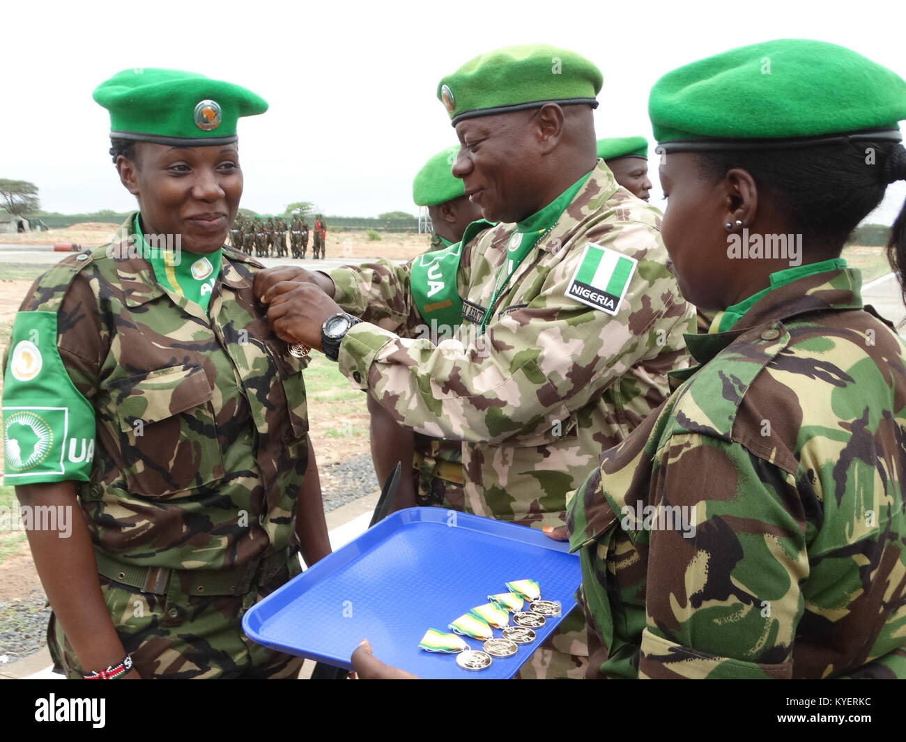 Colonel Yiiska Awolola, from AMISOM Force Headquarters, pins a medal on ...