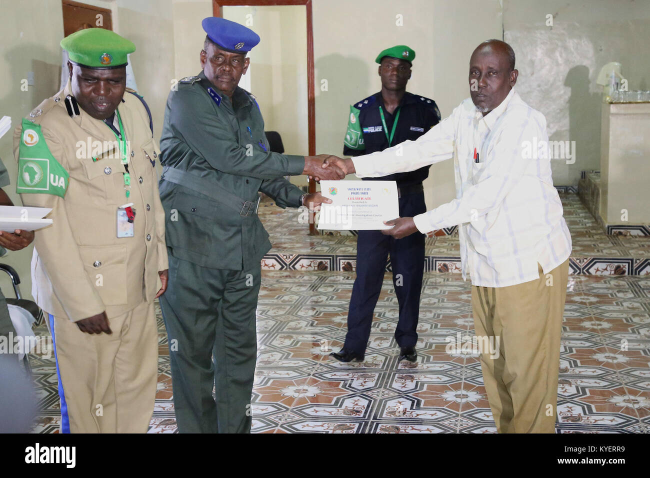 A Somali Police Force officer presenting a certificate to a police ...