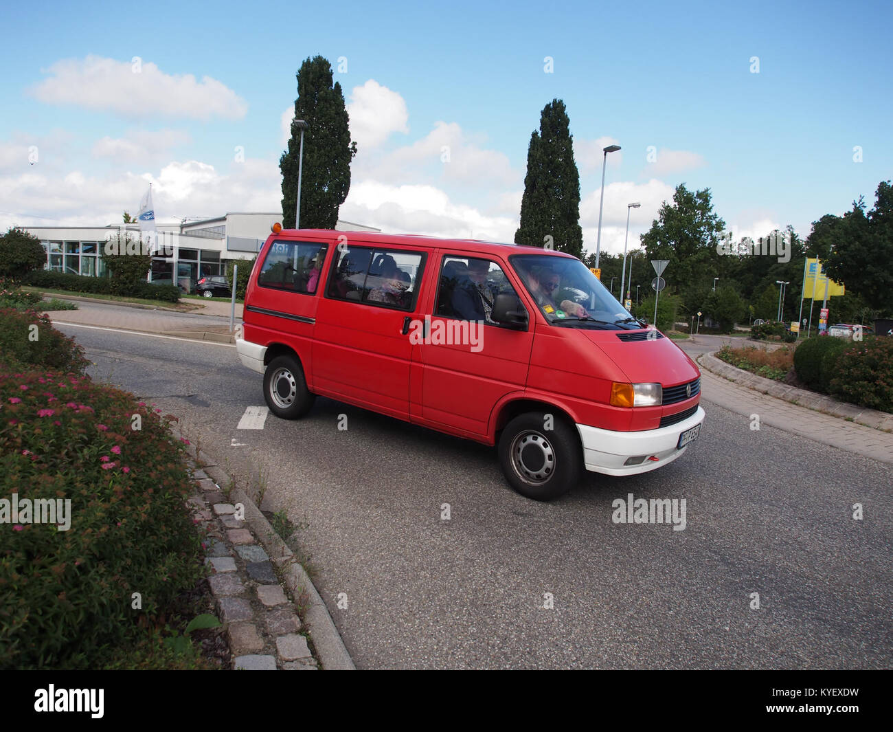 A photograph showing a red Volkswagen car in front of a castle, taken ...