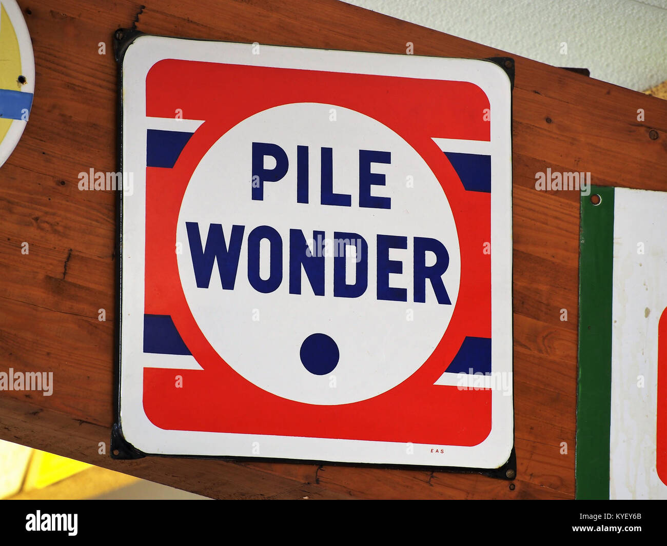 This image shows a vintage enamel advertisement sign displayed at the ...