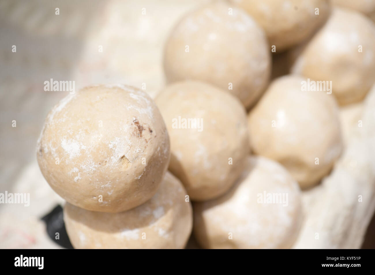 Closeup of raw cereal balls used for making bread in a dirty street of ...