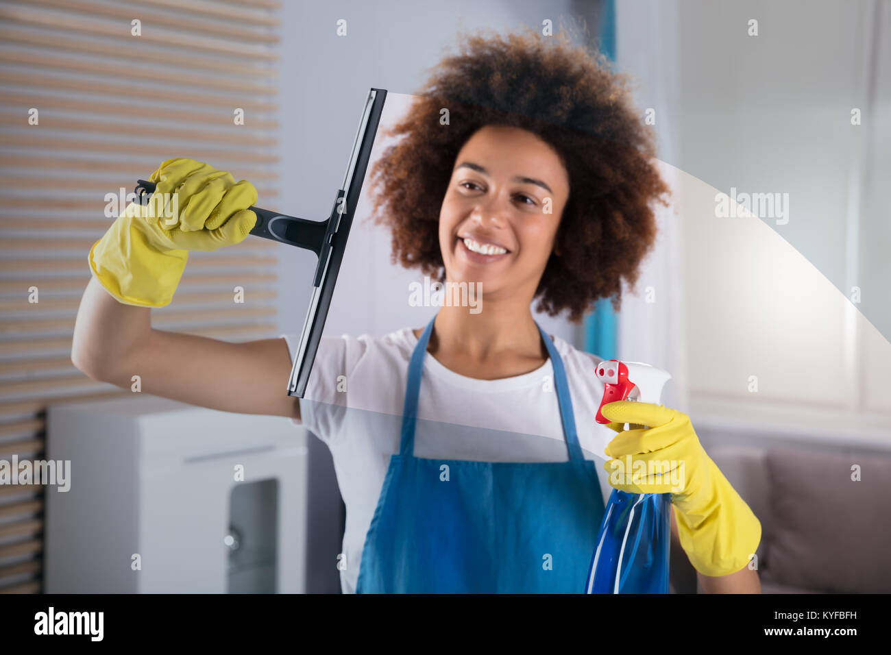 Smiling Young Woman Cleaning Glass Window With Squeegee Stock Photo - Alamy
