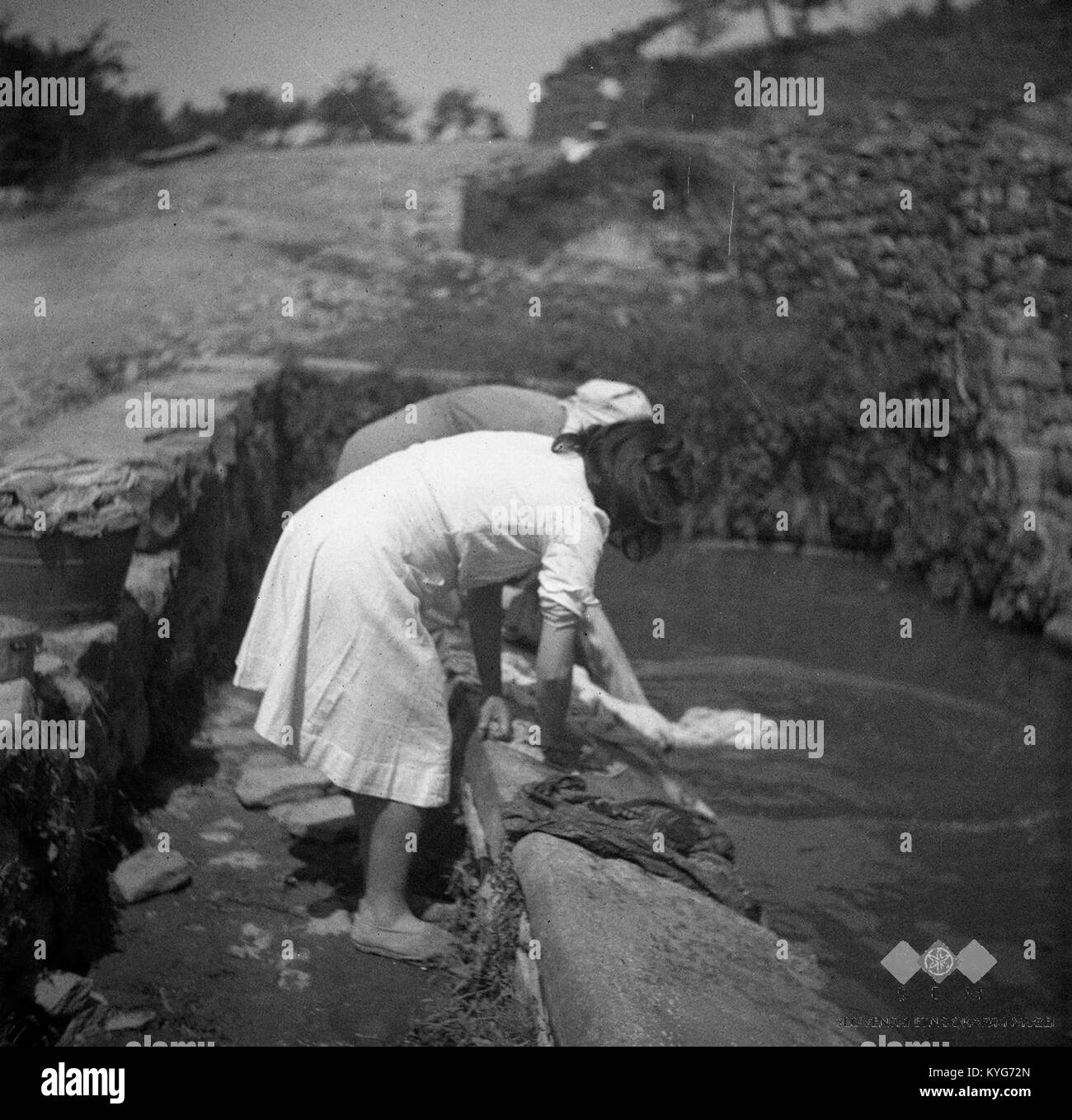 This photograph depicts a woman in traditional attire with a 'perilo ...