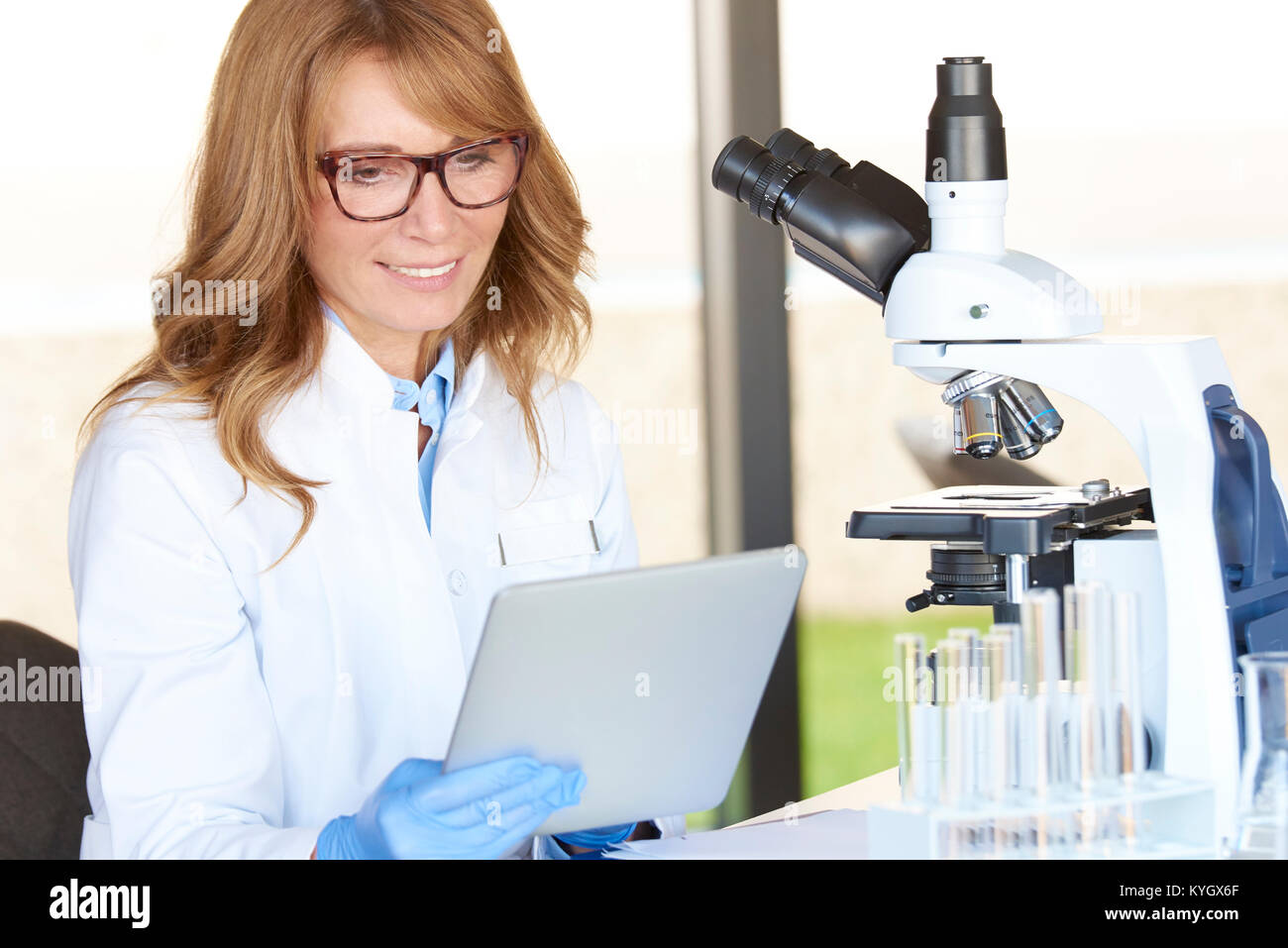 Shot of a smiling middle aged scientist woman working in lab while ...