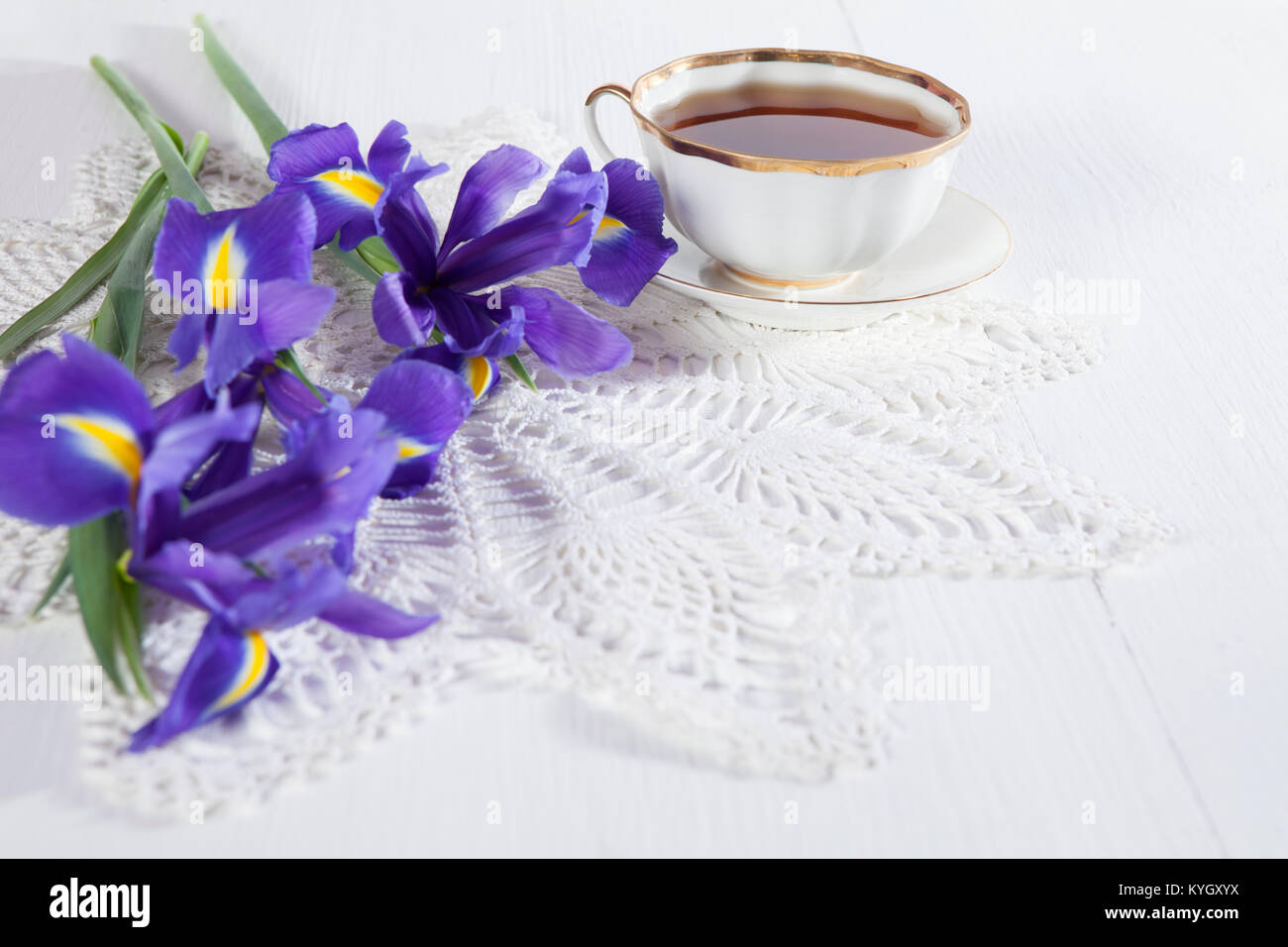 Violet Irises xiphium (Bulbous iris, sibirica) with cup of tea on white ...