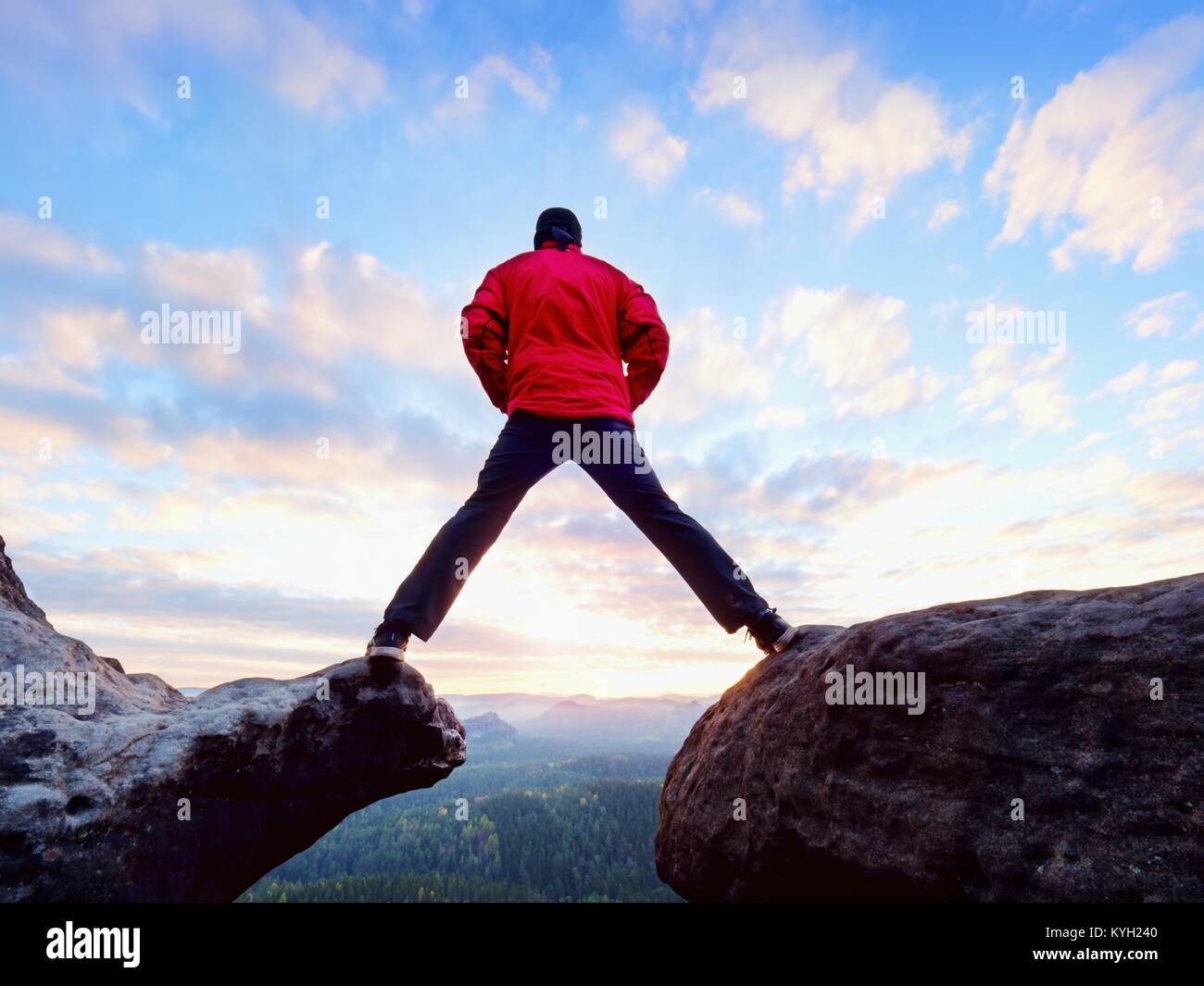 Man jumping from the mountain edge. Man jumping off a cliff without ...