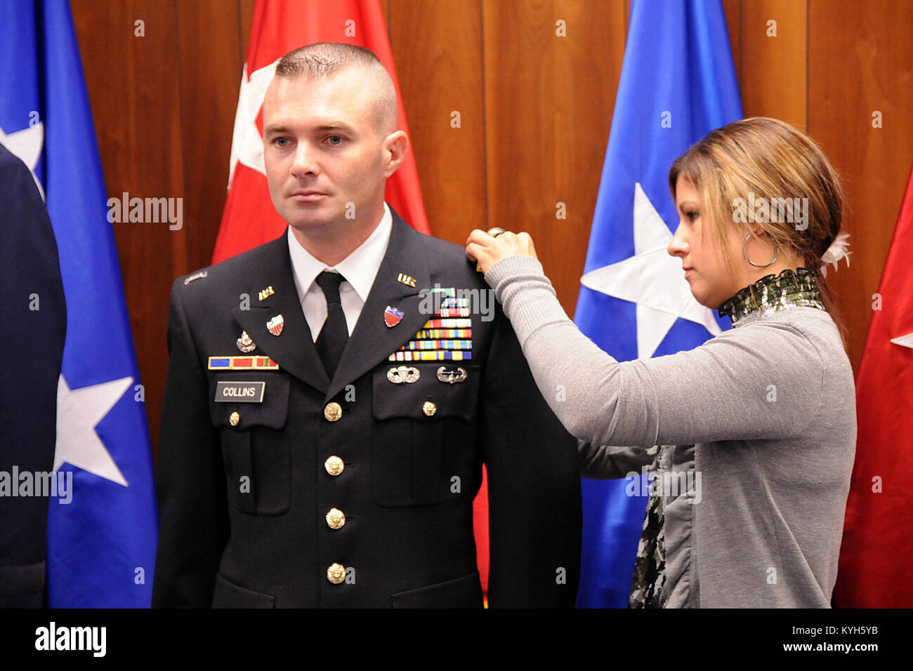 Lora Collins pins warrant officer rank to the uniform of her husband ...
