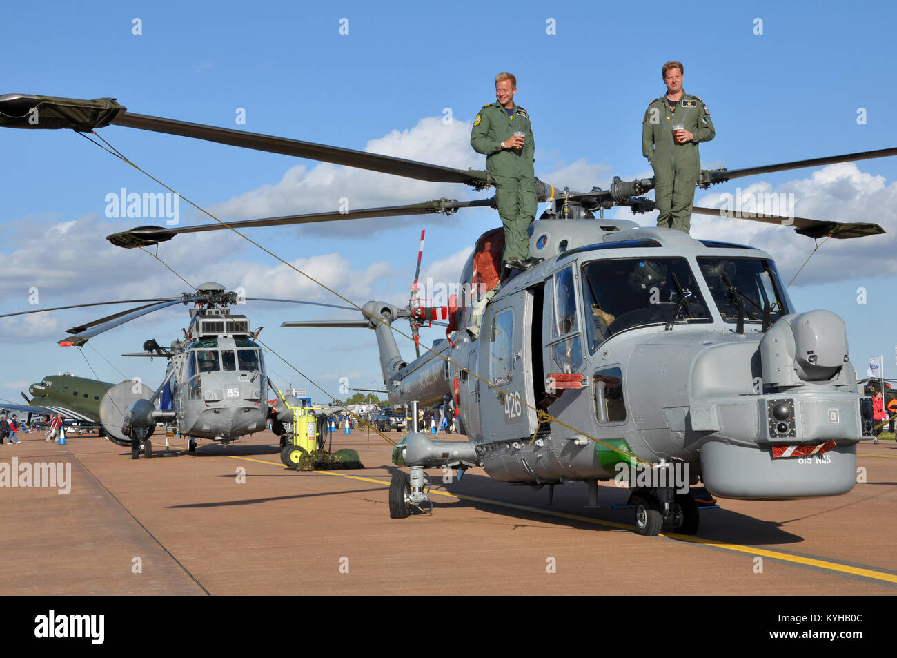 Royal Navy Fleet Air Arm crew relaxing on a Lynx helicopter at an ...
