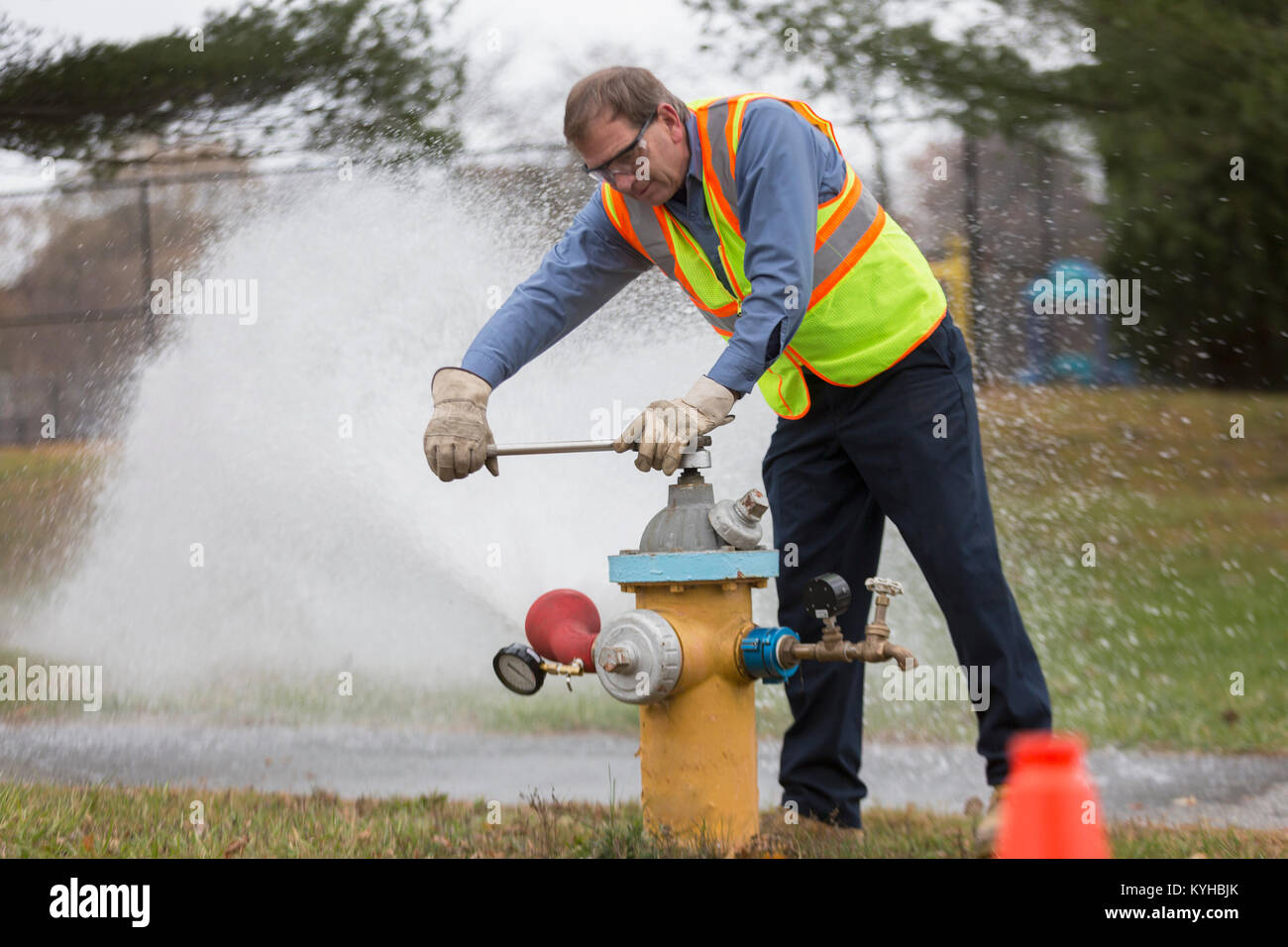 Water department technician opening fire hydrant to flush water pipes ...