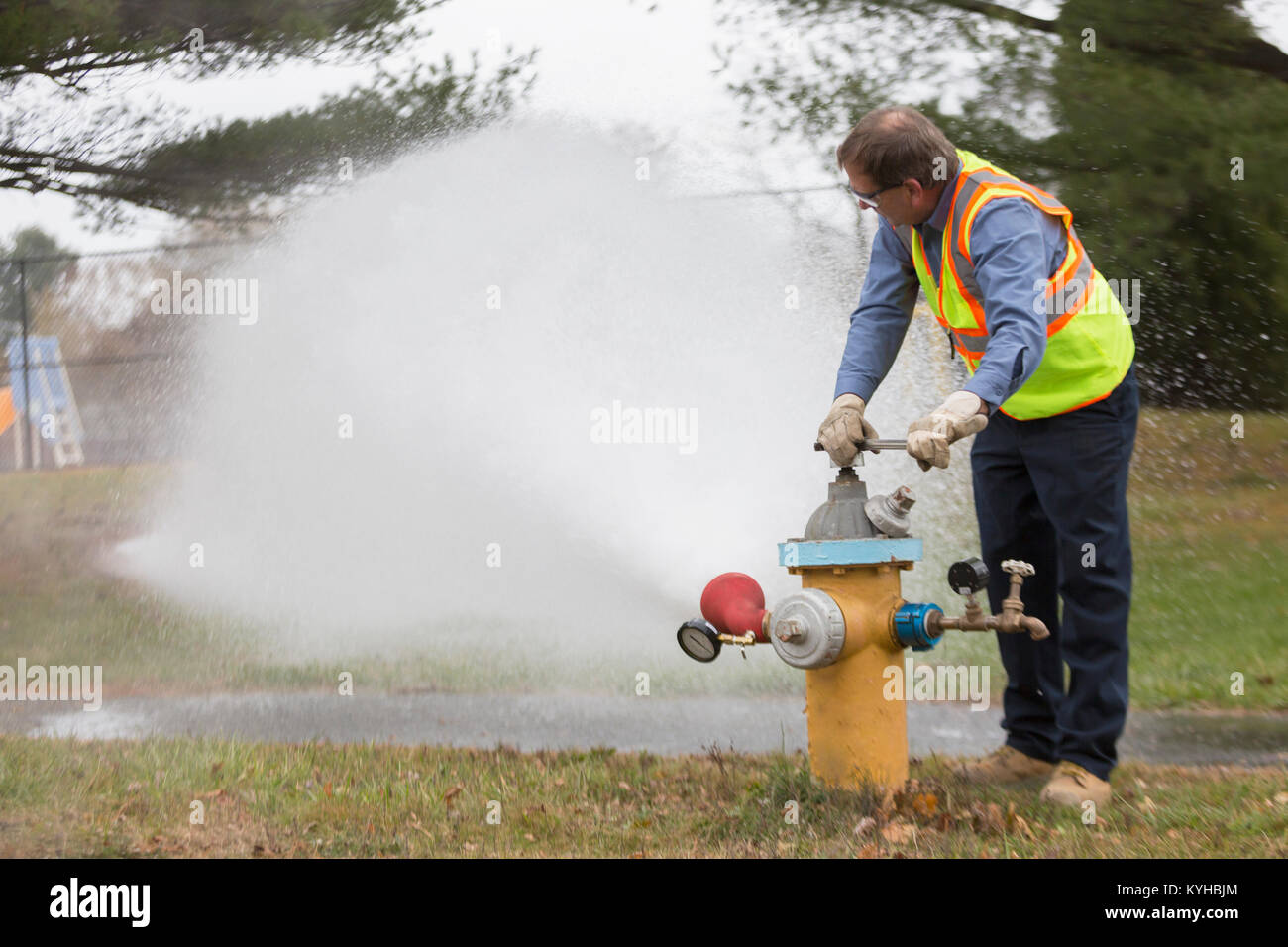 Water department technician opening fire hydrant to flush water pipes ...