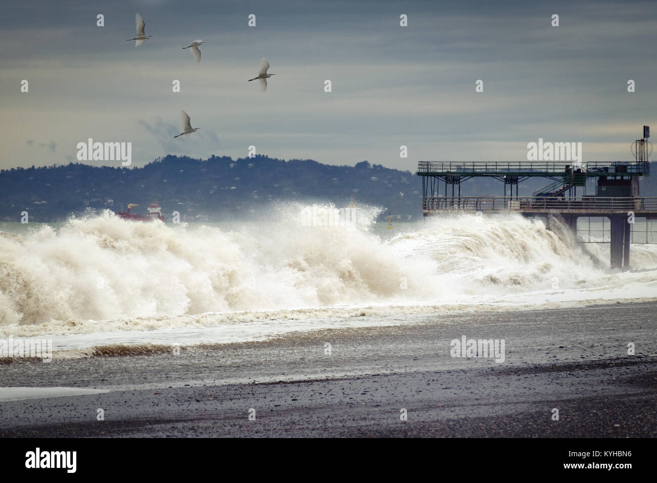 Dramatic weather - a storm on the sea, waves break about the pier ...