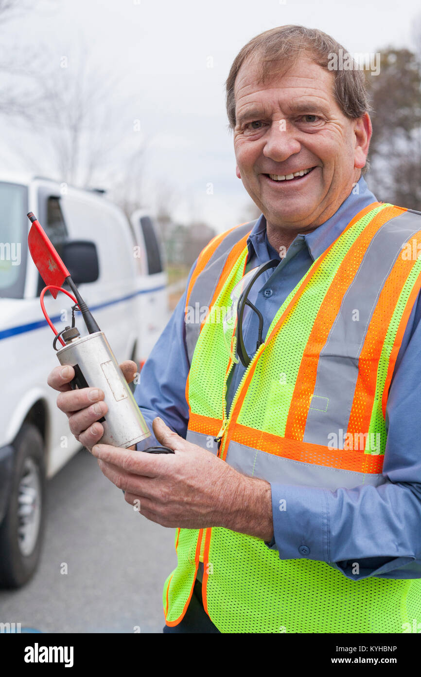 Water department technician holding leak sensor Stock Photo - Alamy