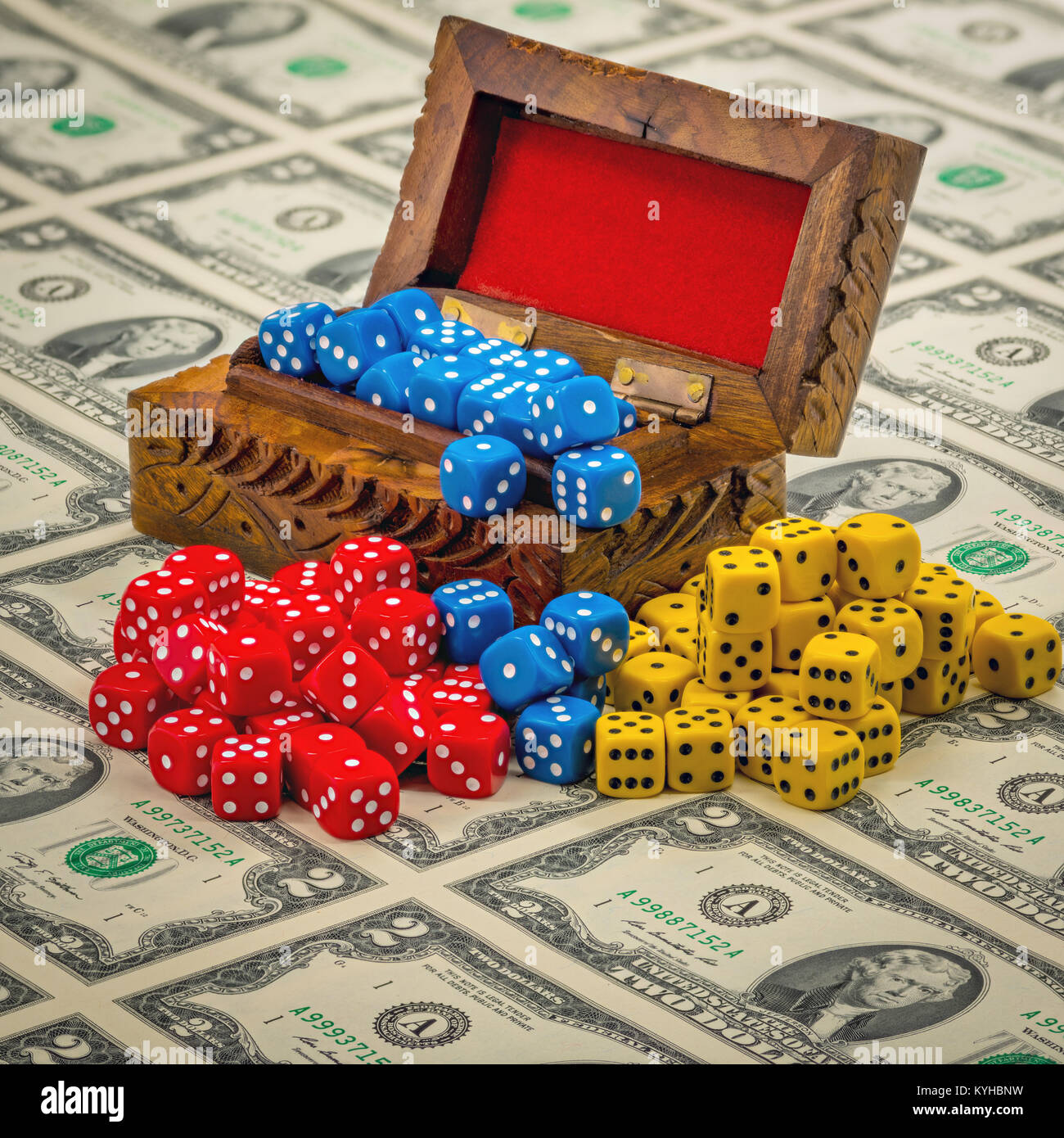 Small plastic dice of different colors spill onto a sheet of dollar ...