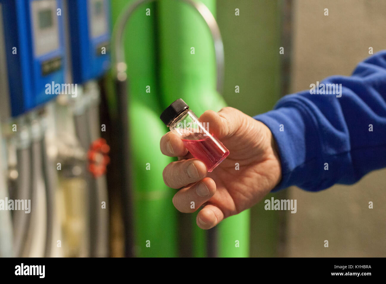 Water treatment engineer examining color of sample vile Stock Photo - Alamy