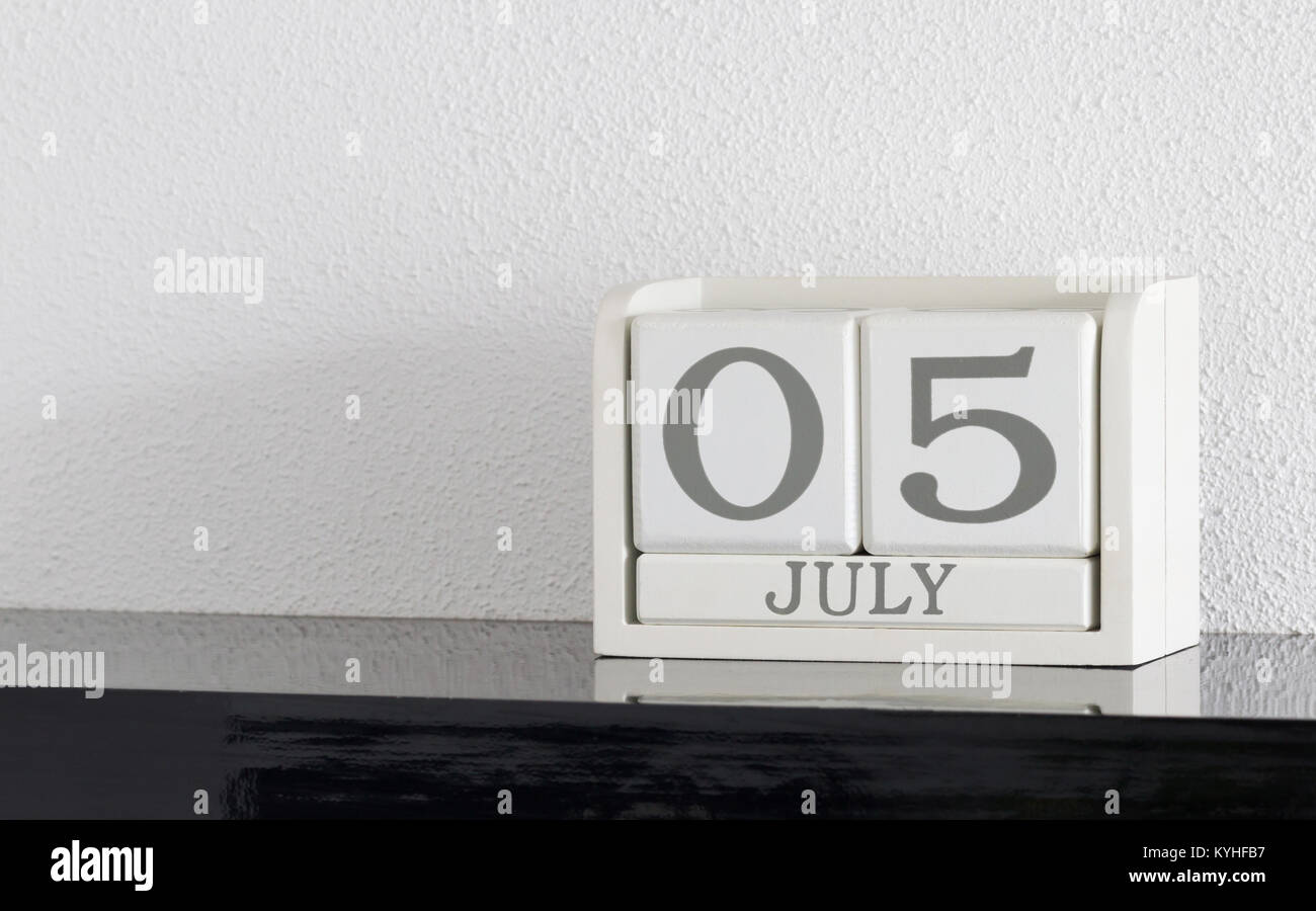 White block calendar present date 5 and month July on white wall ...