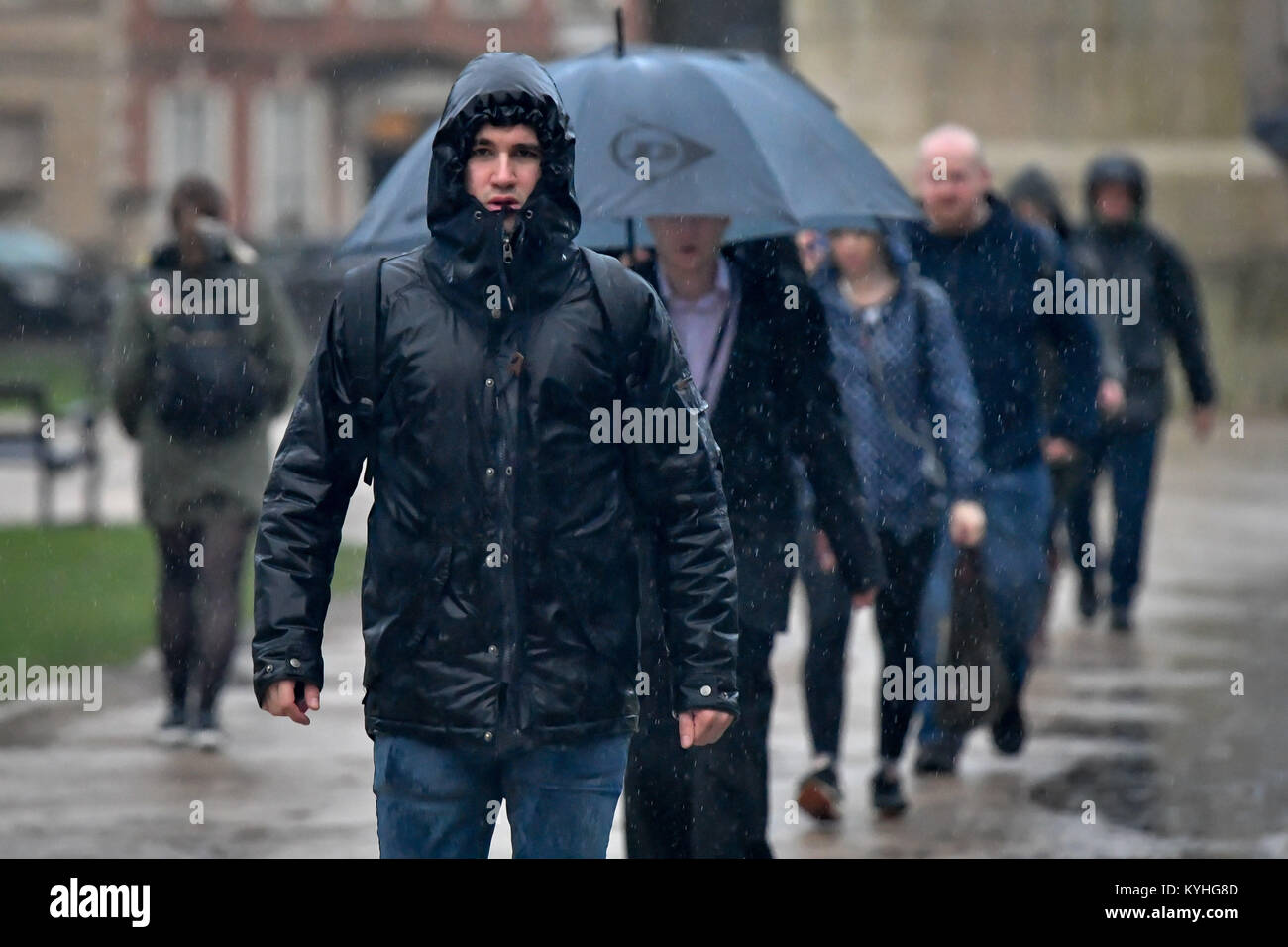 A man walks in pouring rain as people commute to work through Queen's ...