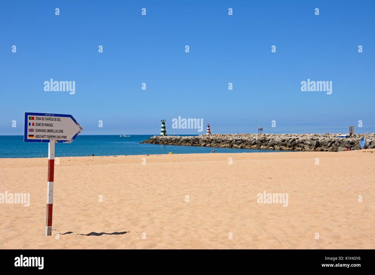 Sunshade umbrellas zone sign on the beach leading towards the harbour ...
