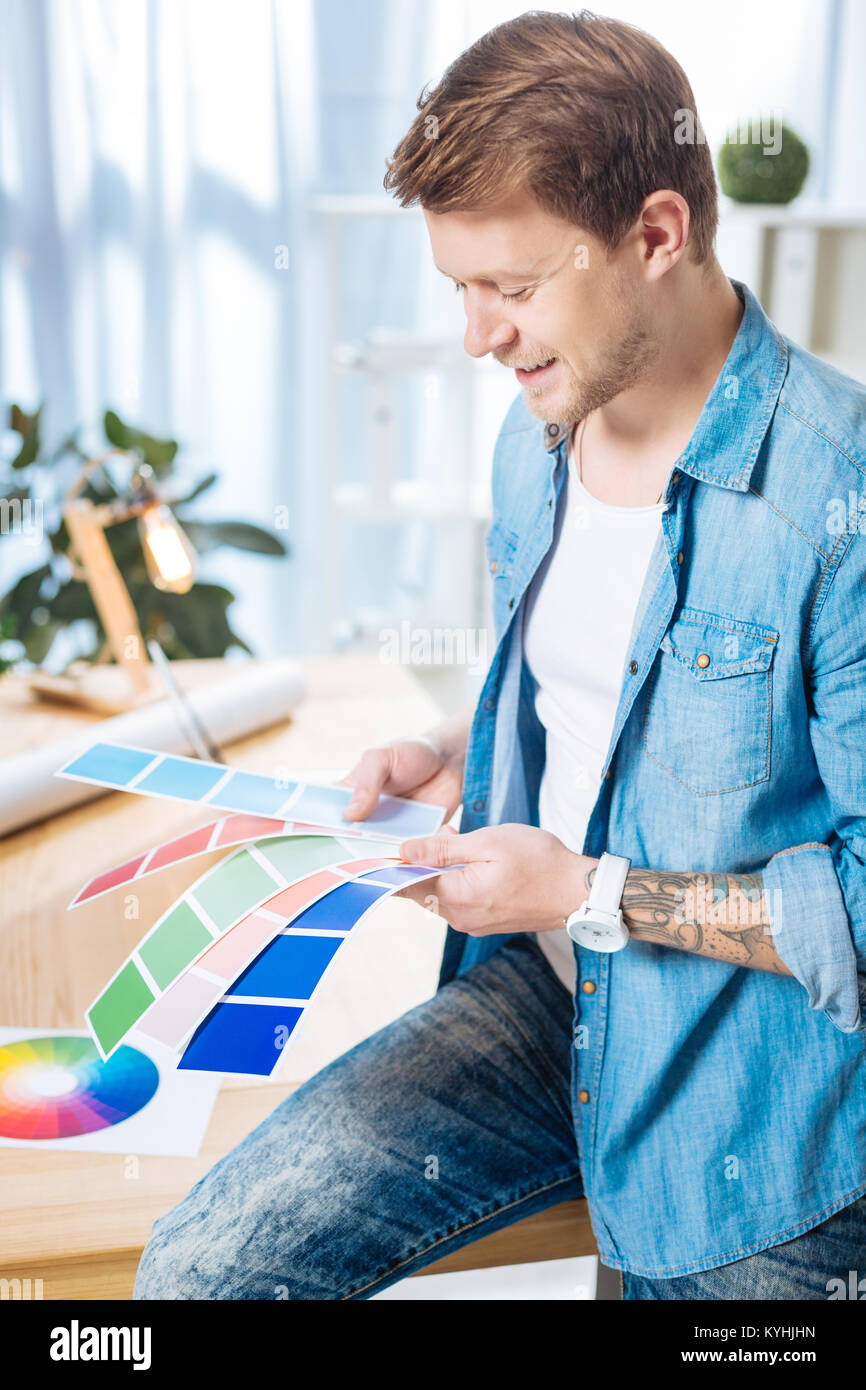 Experienced designer holding color palettes and smiling happily Stock ...