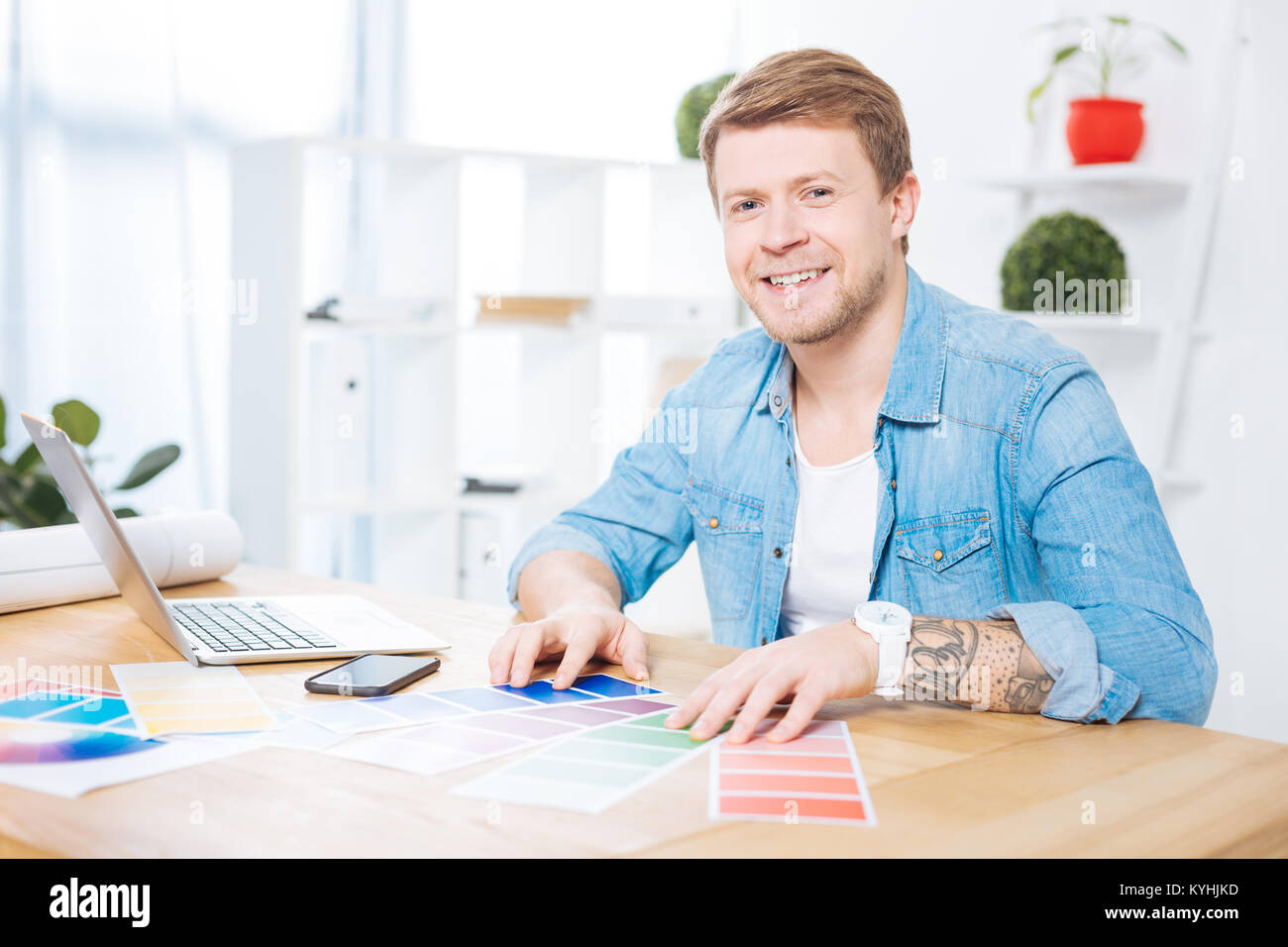 Happy designer siting at the table with color palettes on it Stock ...
