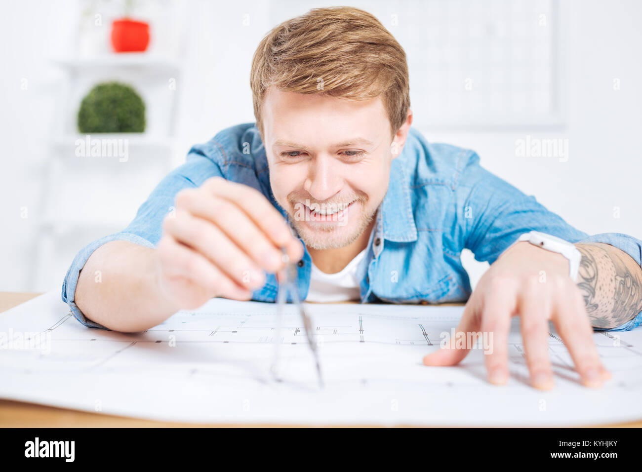 Happy engineer smiling while holding a pair of compasses Stock Photo ...