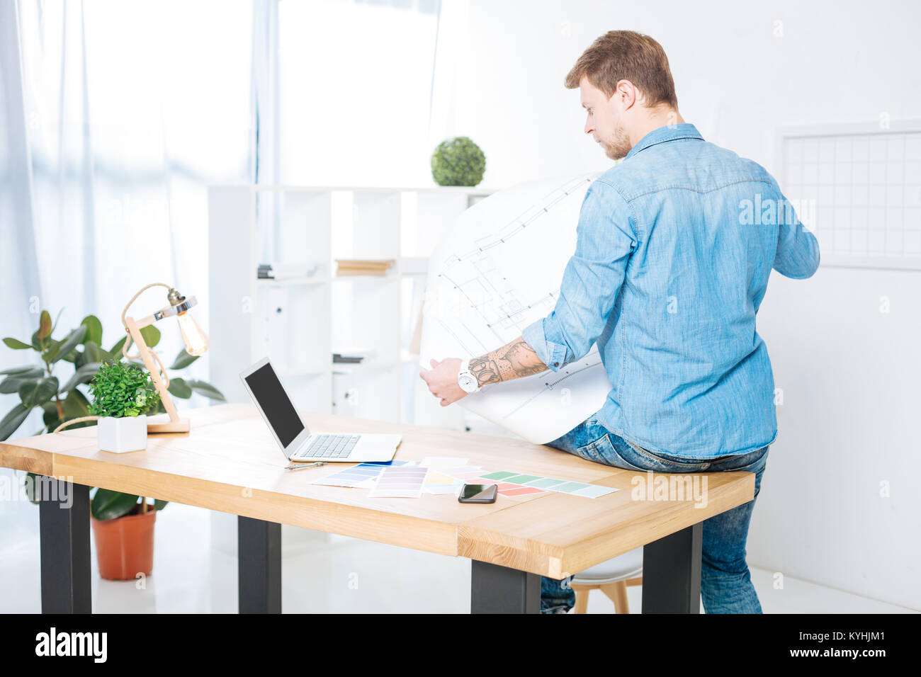 Calm engineer looking at the drawing and thinking Stock Photo - Alamy