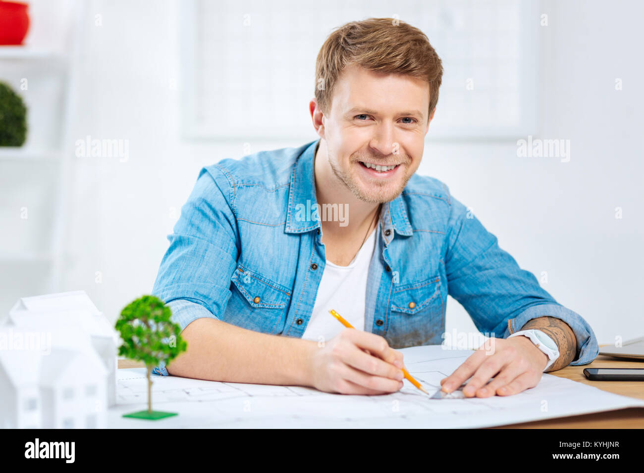 Handsome young engineer smiling while making his project Stock Photo ...
