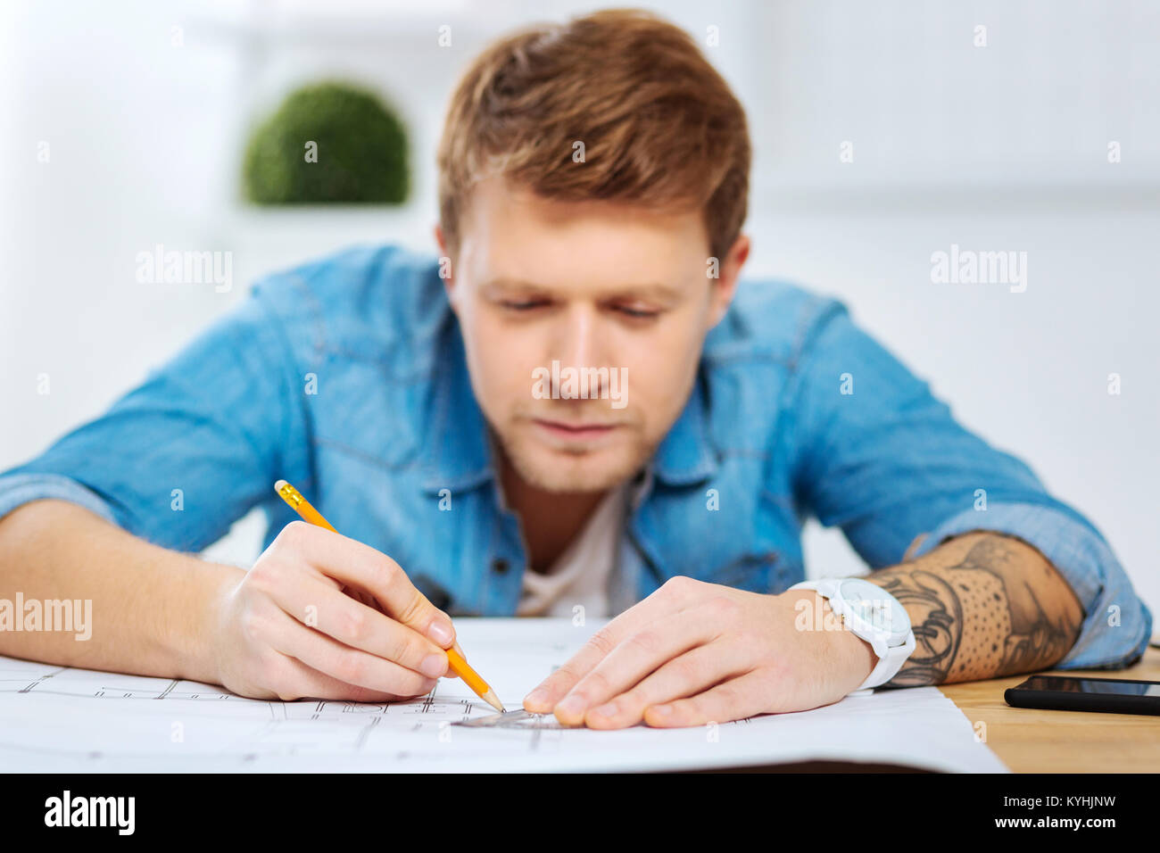 Concentrated engineer looking careful while drawing lines Stock Photo ...