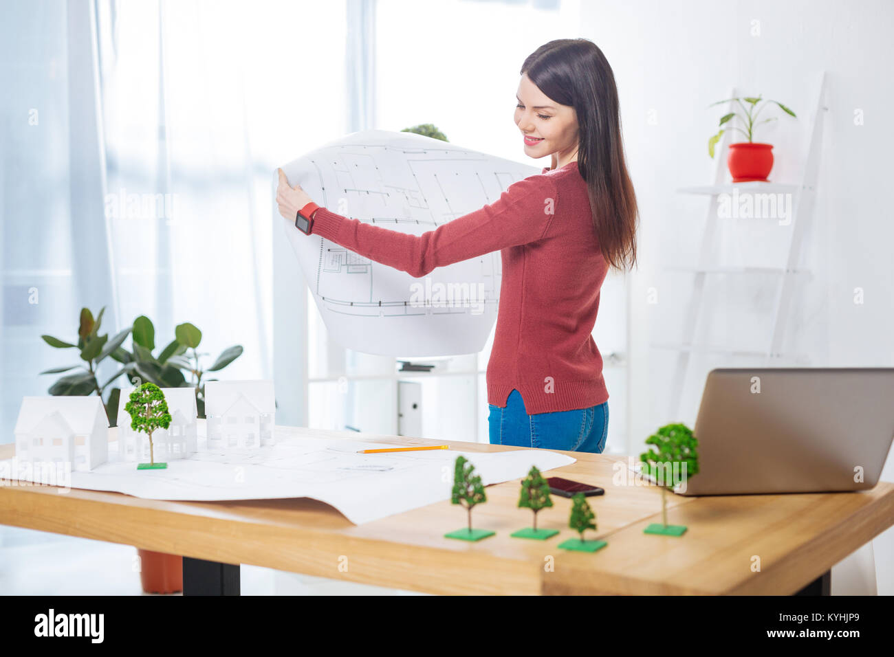 Cheerful engineer smiling while comparing two detailed schemes Stock ...