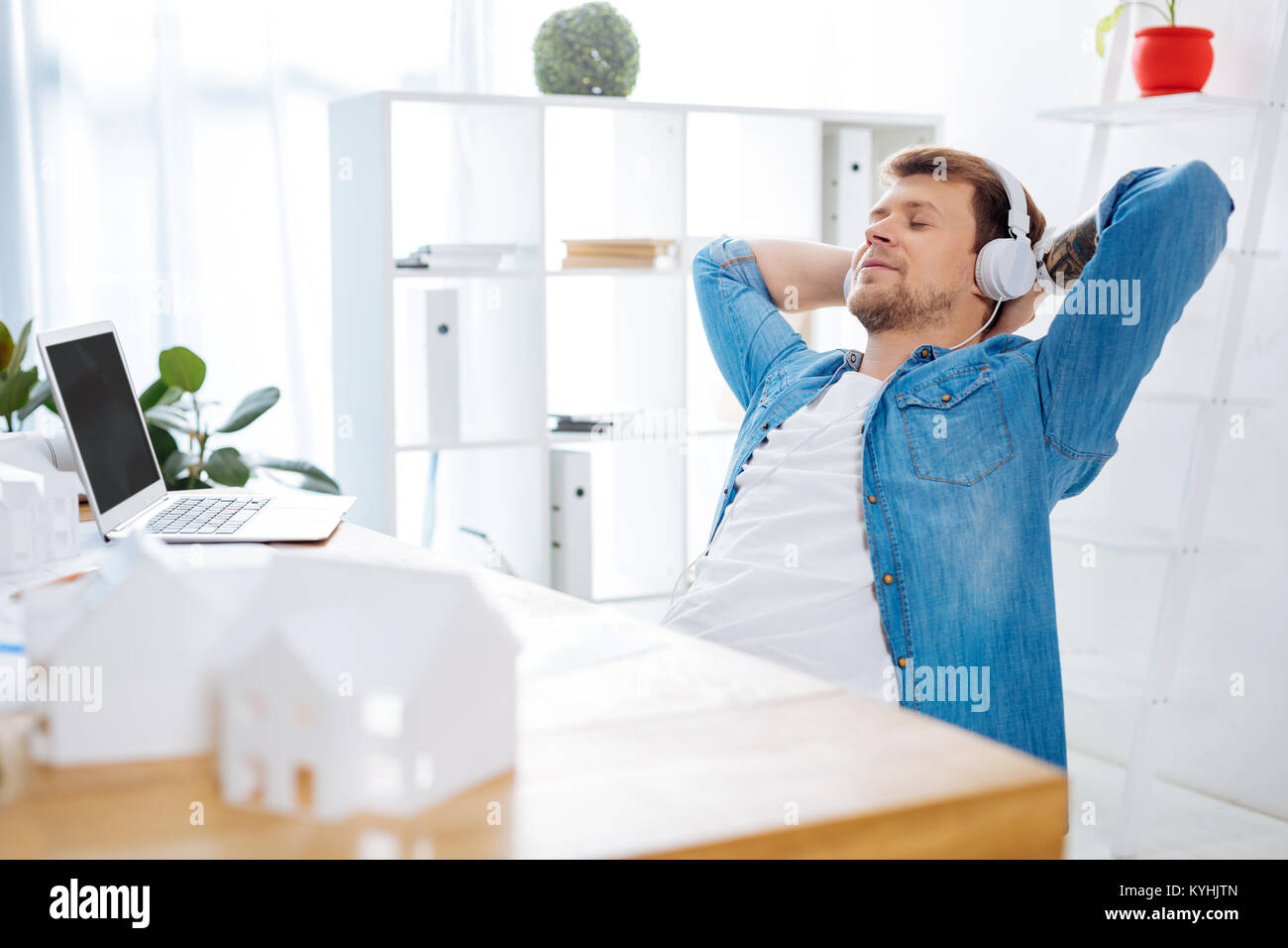 Skilled engineer relaxing at work while listening to music Stock Photo ...