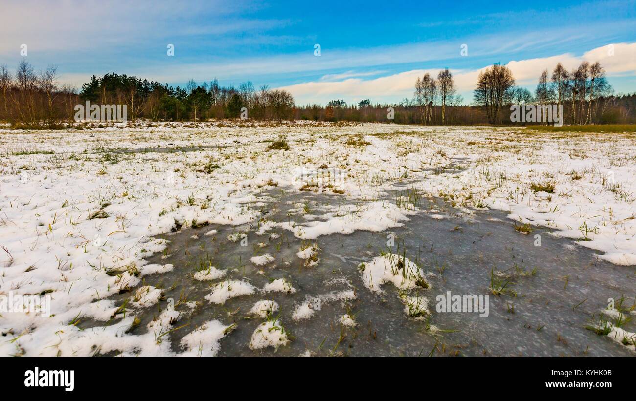 Winter meadows with snow and frozen puddle. Beautiful polish landscape ...
