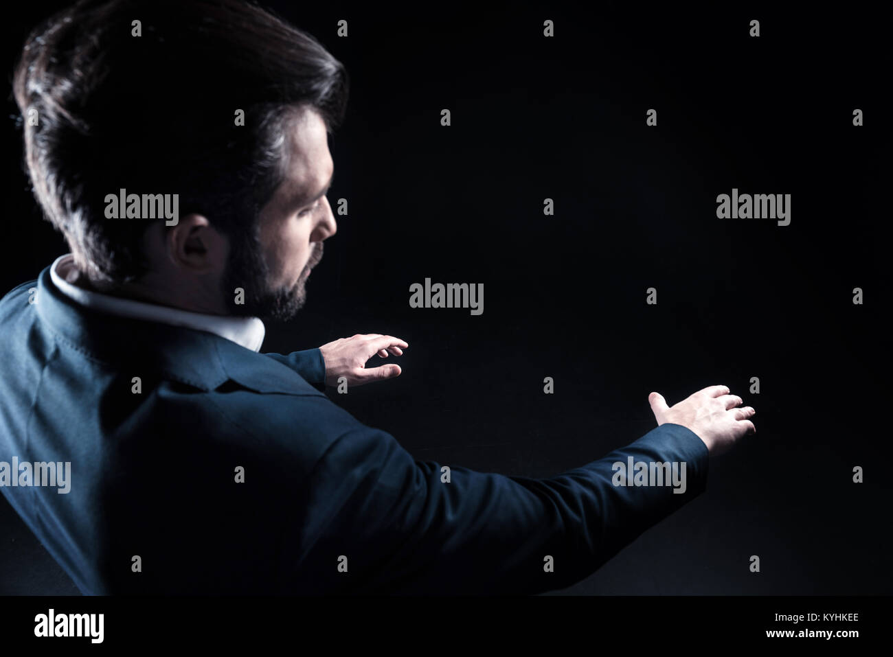 Nice smart man looking at his hands Stock Photo - Alamy