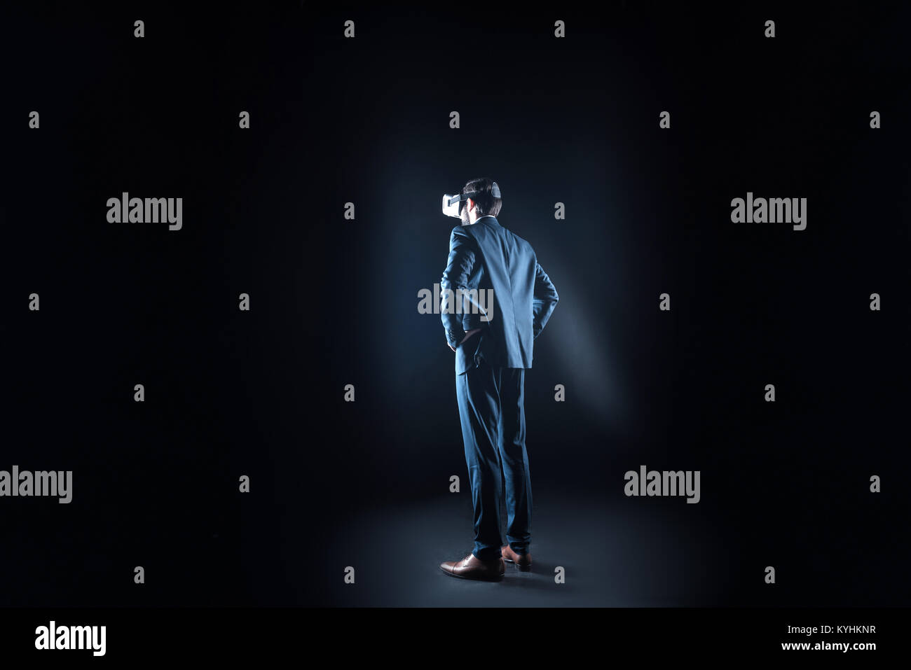 Smart adult man standing against black background Stock Photo - Alamy