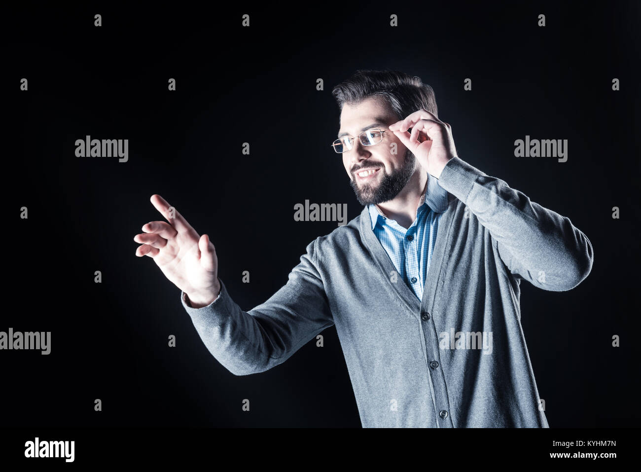 Positive smart man fixing his glasses Stock Photo - Alamy