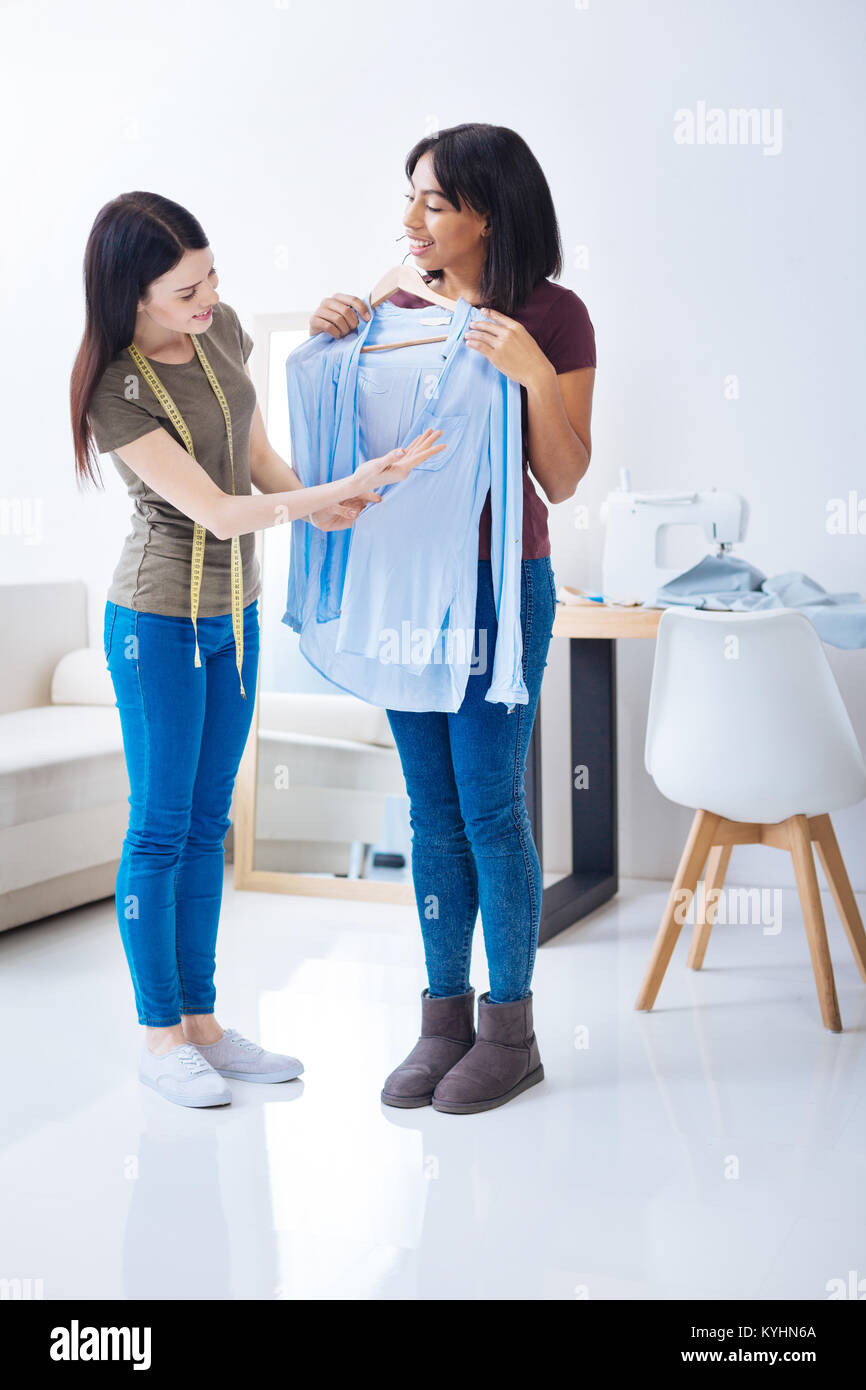 Smart tailor showing a beautiful blouse to her attentive client Stock ...