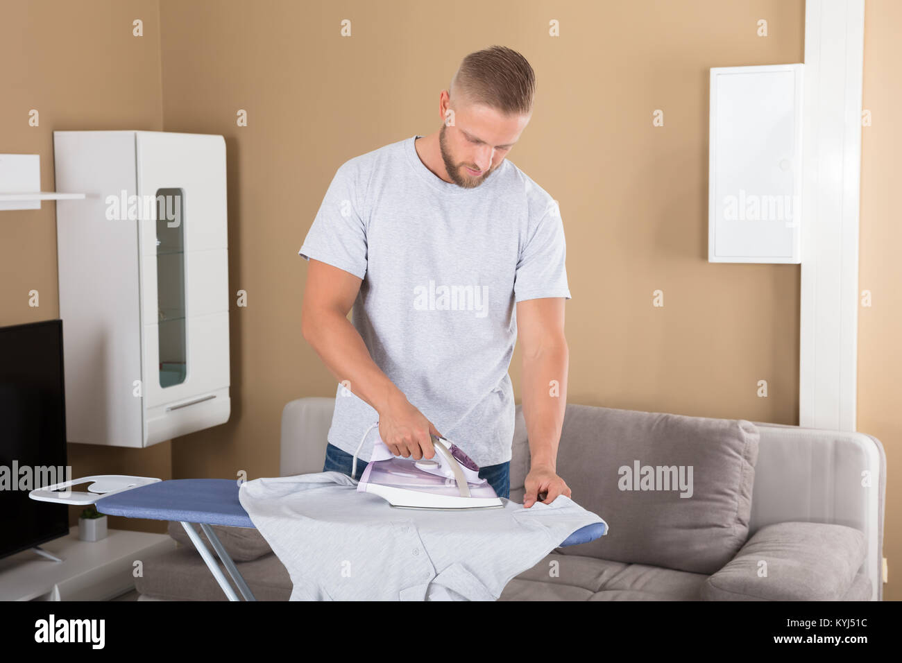 Young Man Ironing Cloth On Iron Board Stock Photo - Alamy