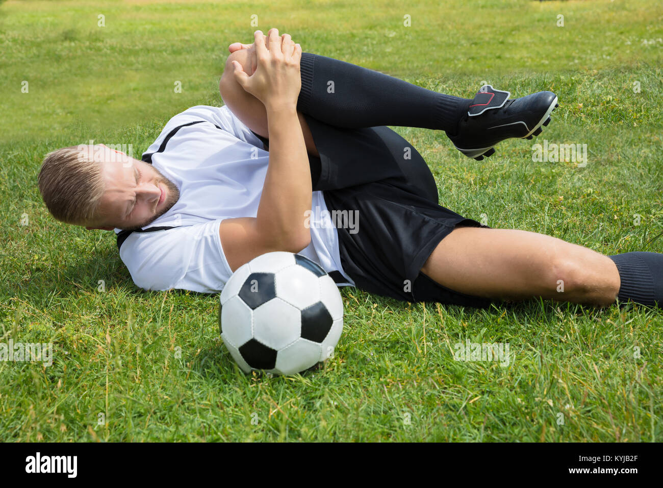 Close-up Of Male Soccer Player Suffering From Knee Injury Lying On ...