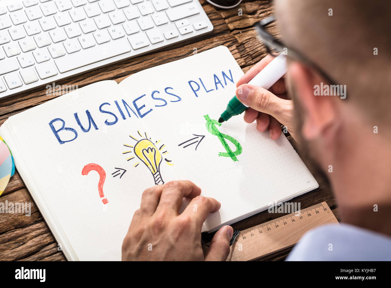 Close-up Of Businessman Drawing Business Plan On Notebook Over The ...