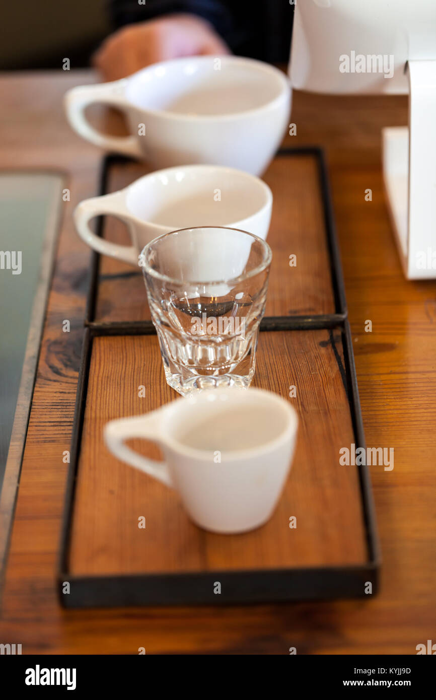 Coffee cups of various sizes next to tablet register in coffee shop on ...