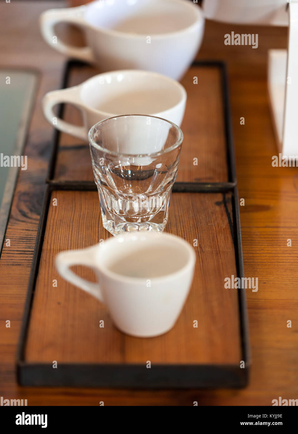 Coffee cups of various sizes next to tablet register in coffee shop on ...