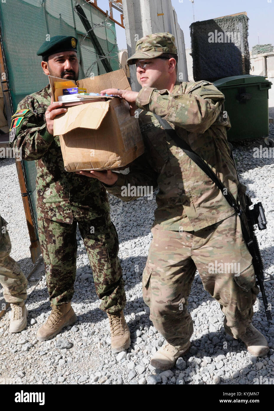 An Afghan National Army soldier passes a box of supplies to Sgt. Eric ...