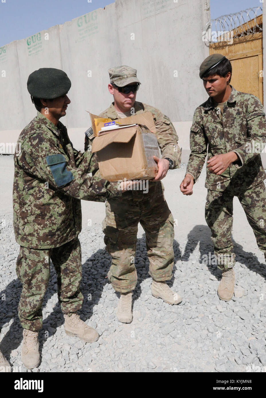 An Afghan National Army soldier passes a box of school supplies to Air ...